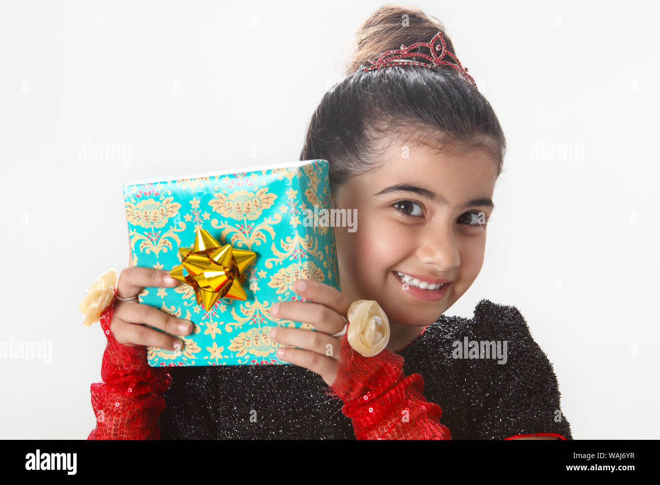 Indian girl holding a gift box and smiling Stock Photo - Alamy
