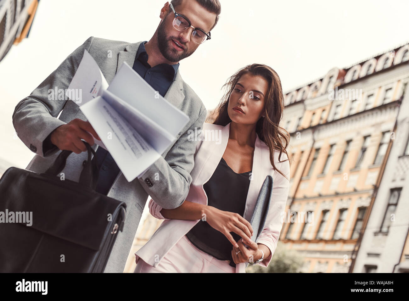 Cropped portrait of man and woman talking to each other while walking ...