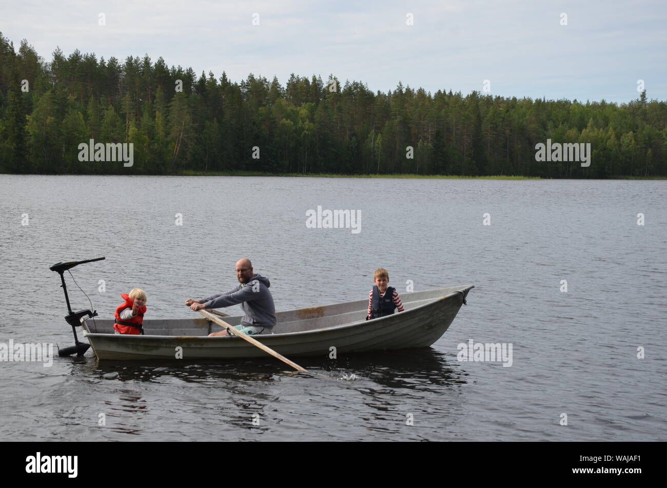 Father and sons in rowing boat on Lake Sarkjarvi, Mikkeli, Finland ...