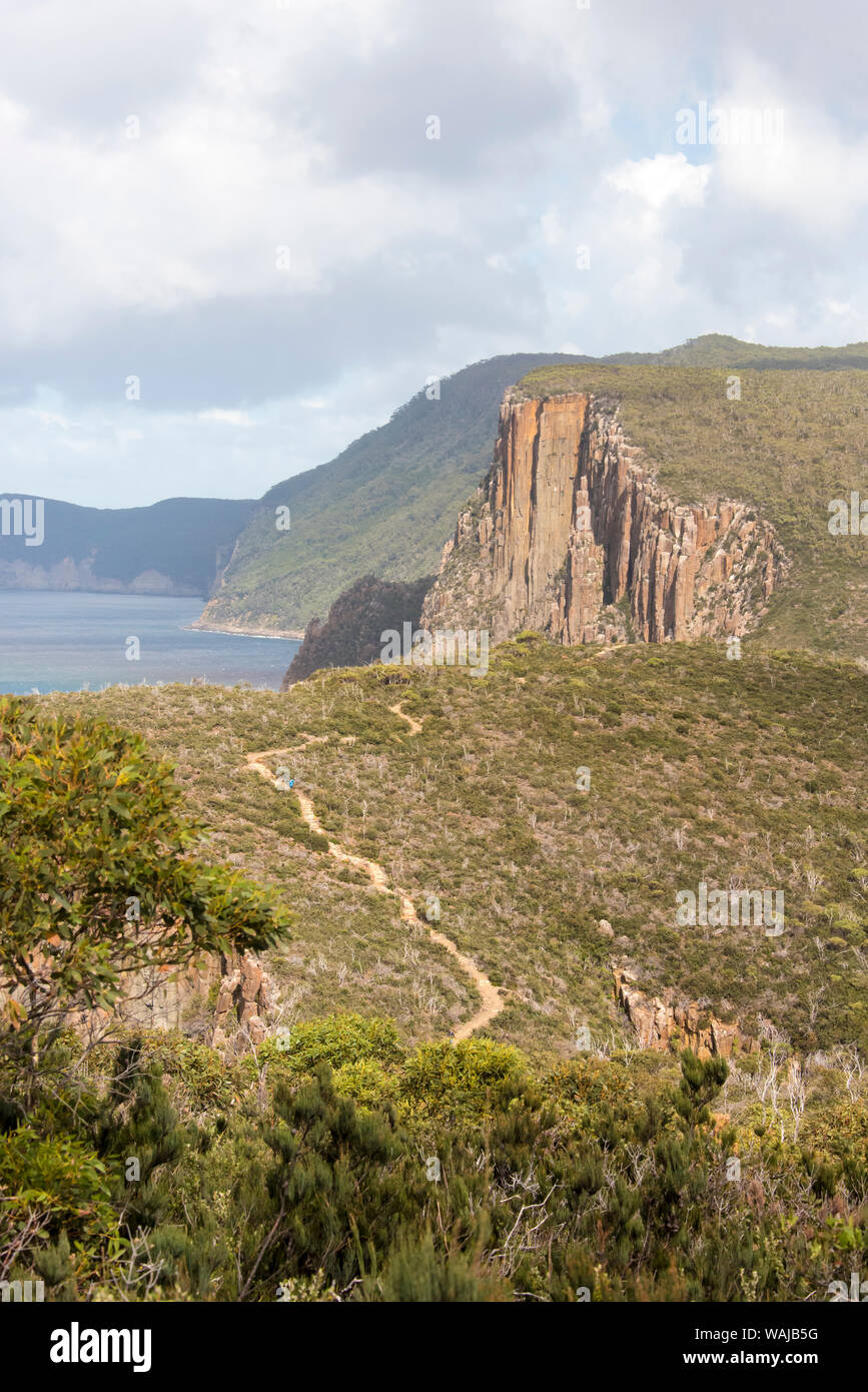 Australia, Tasmania. Colorfully clothed hiker standing out on Cape Hauy ...