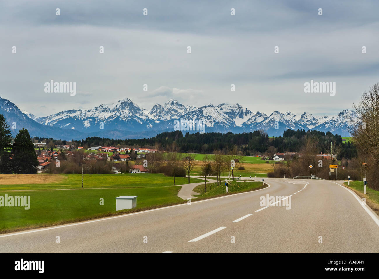 Street curving into a mountain town in the foothills of the Alps in ...