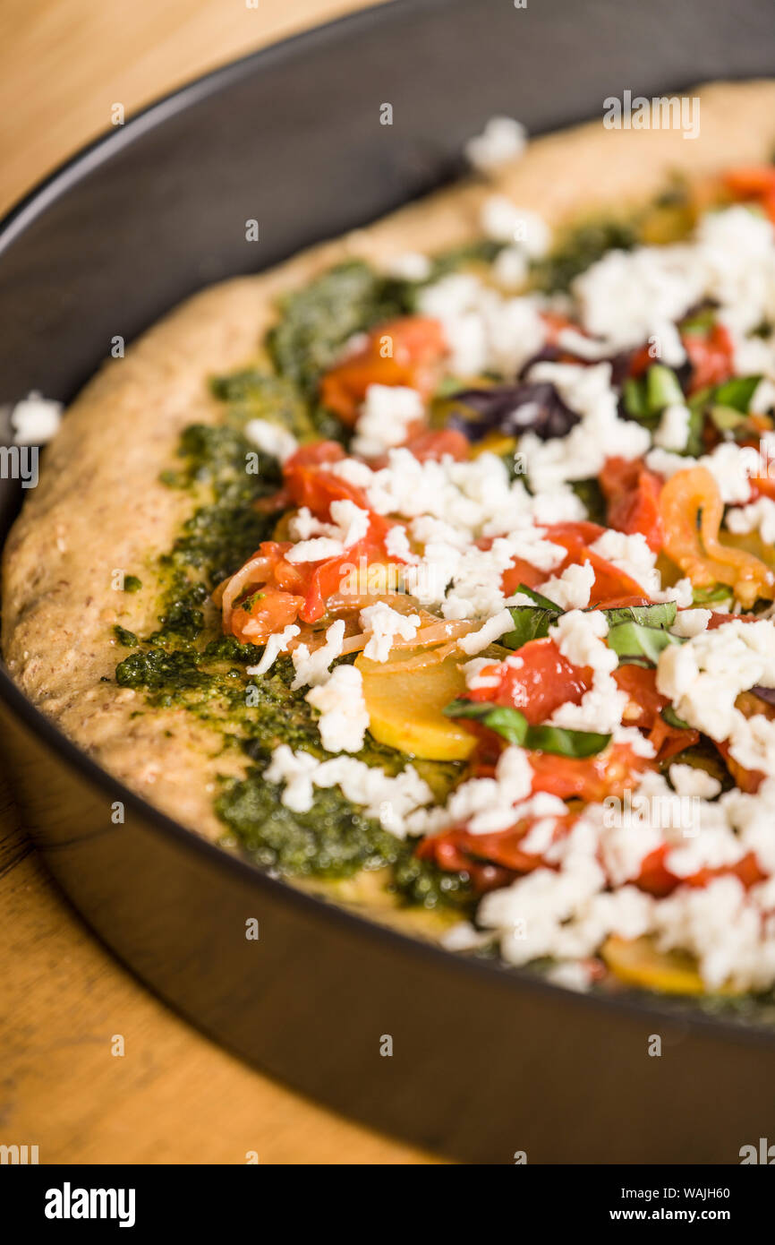 Grated mozzarella cheese on a homemade unbaked, vegetarian, multi-grain ...