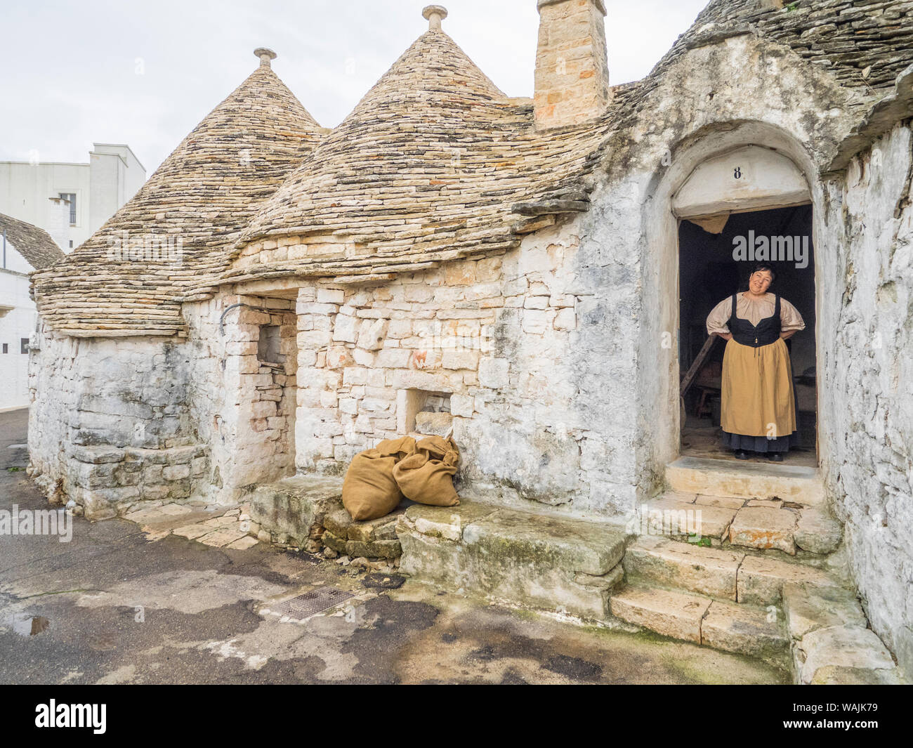 Italy, Alberobello. Woman in traditional clothes in doorway Stock Photo ...