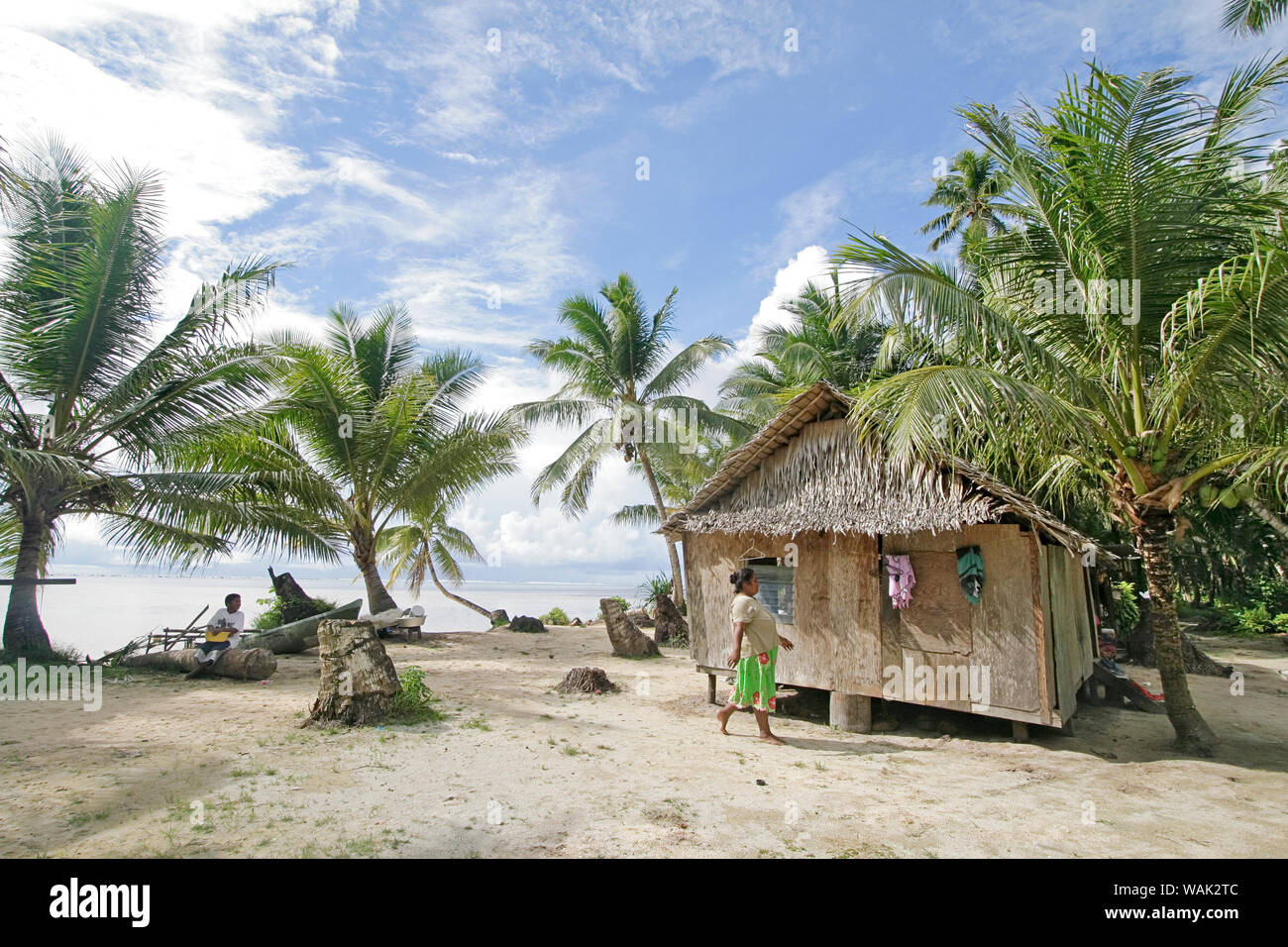 Kosrae, Micronesia (FSM). Local woman walking to her palm thatch house ...