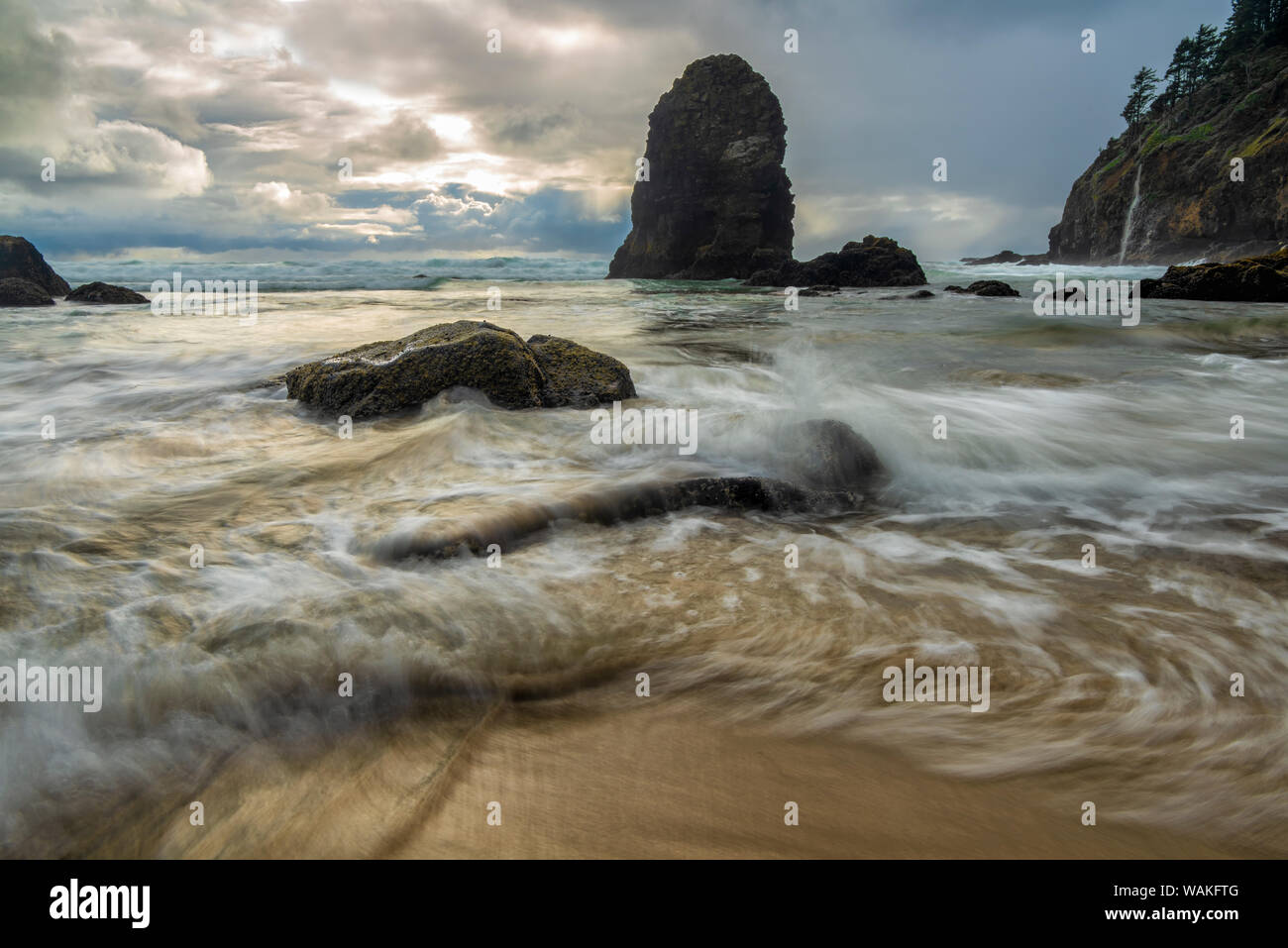 Swirling water around rocks on a beach Stock Photo - Alamy