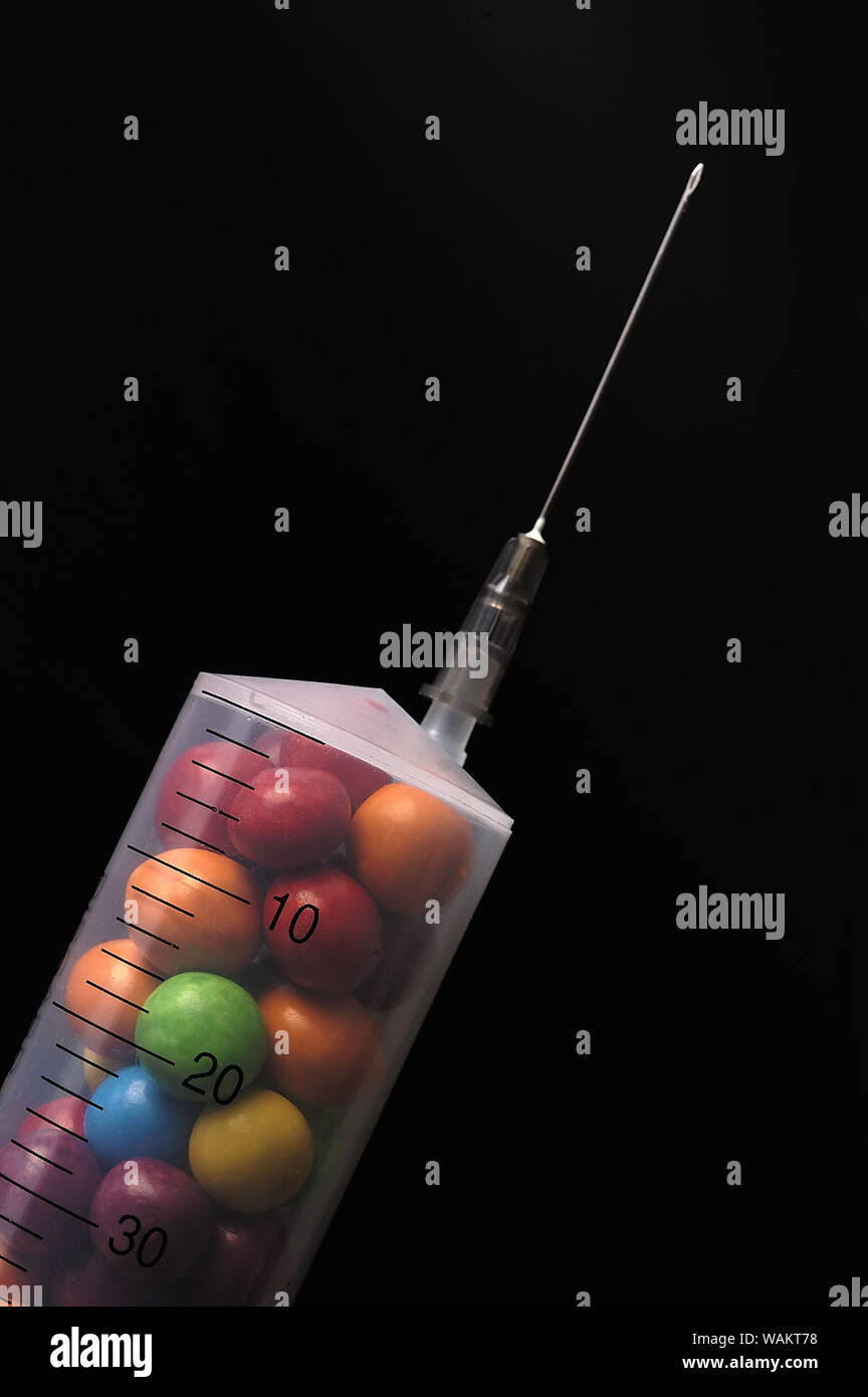Close up of a syringe filled with candy in isolated Stock Photo - Alamy