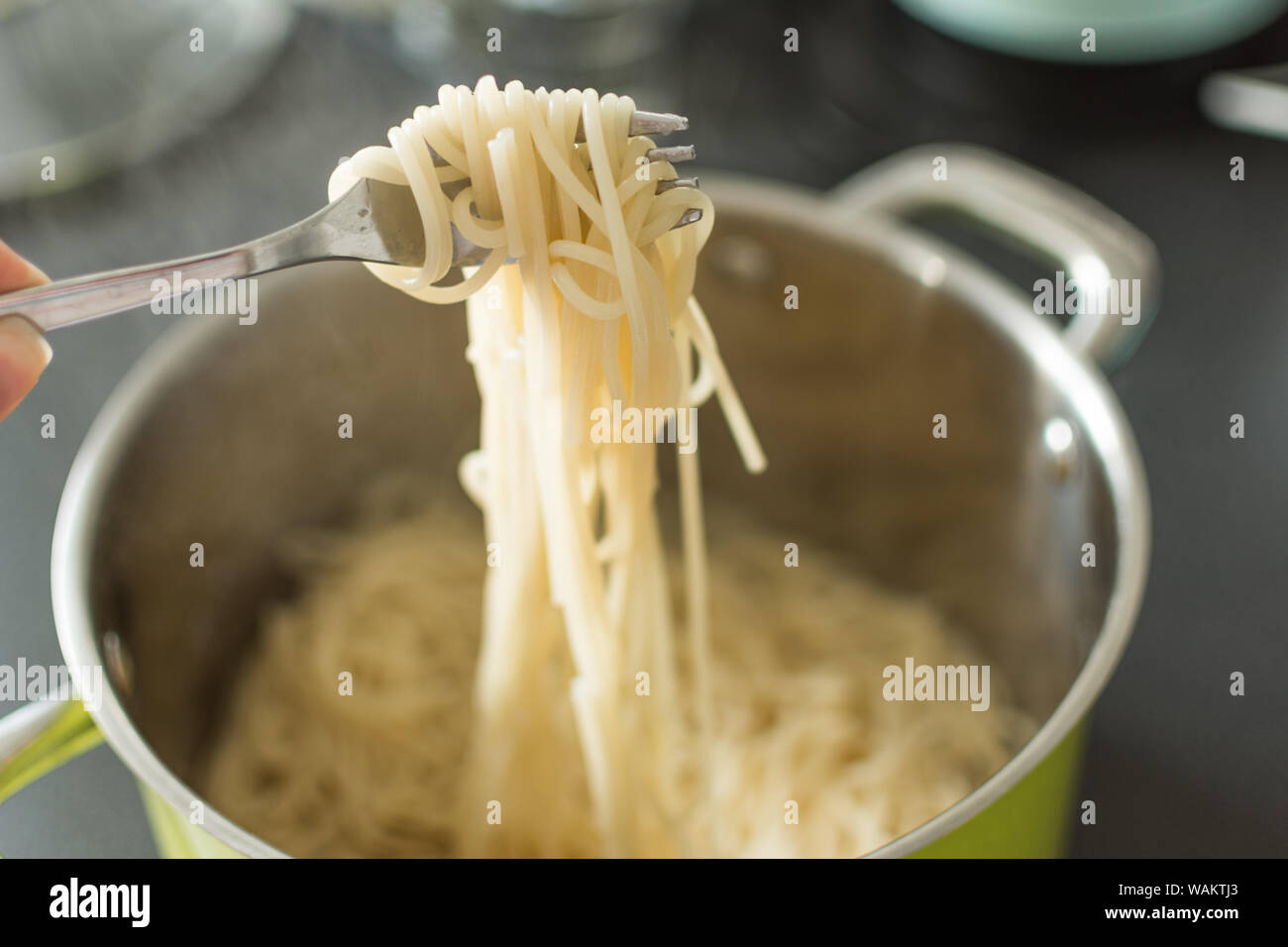 Boiled spaghetti hanging from a fork in the pan background. Spaghetti ...