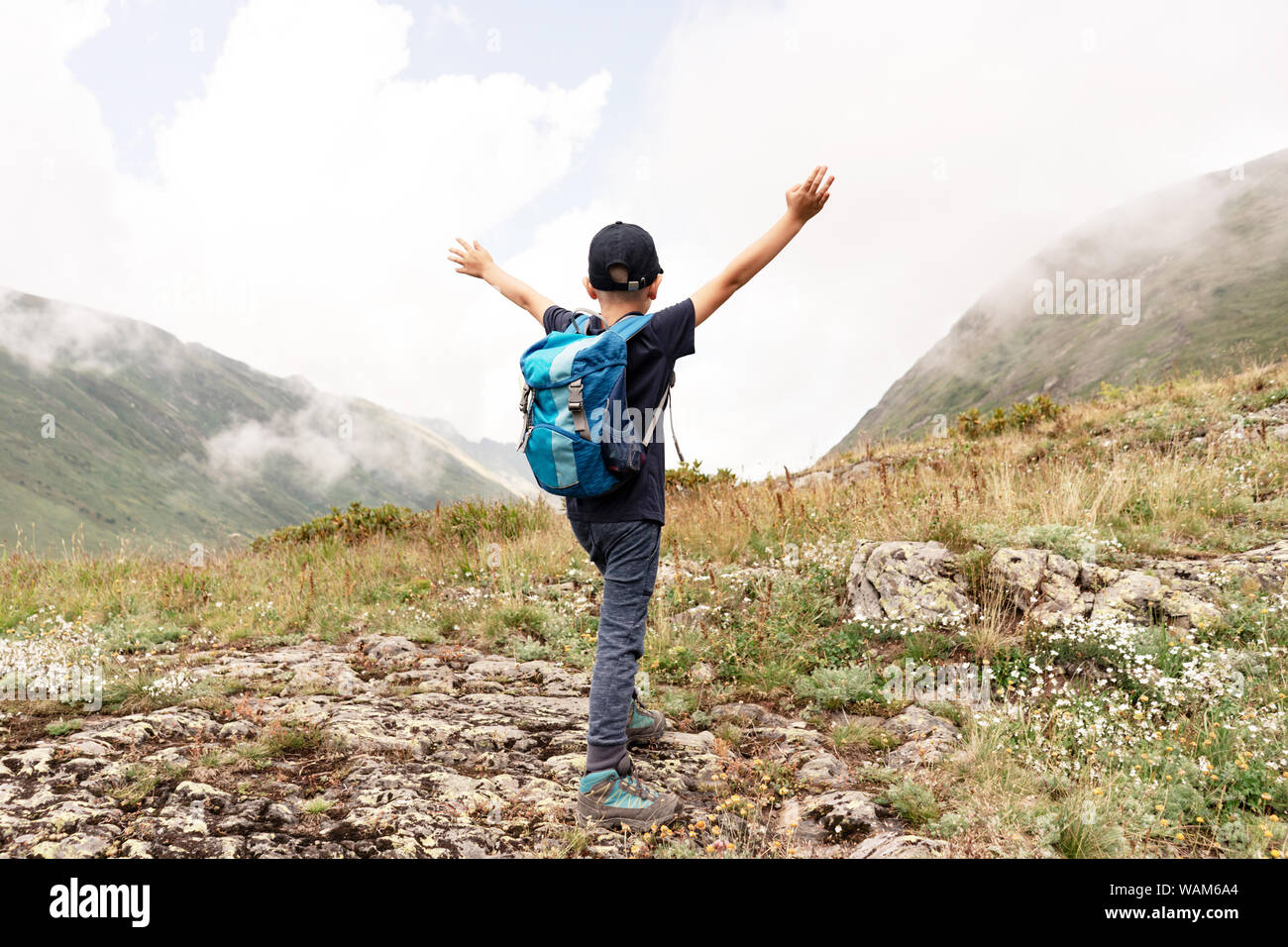 boy with a backpack on top of a mountain Stock Photo - Alamy