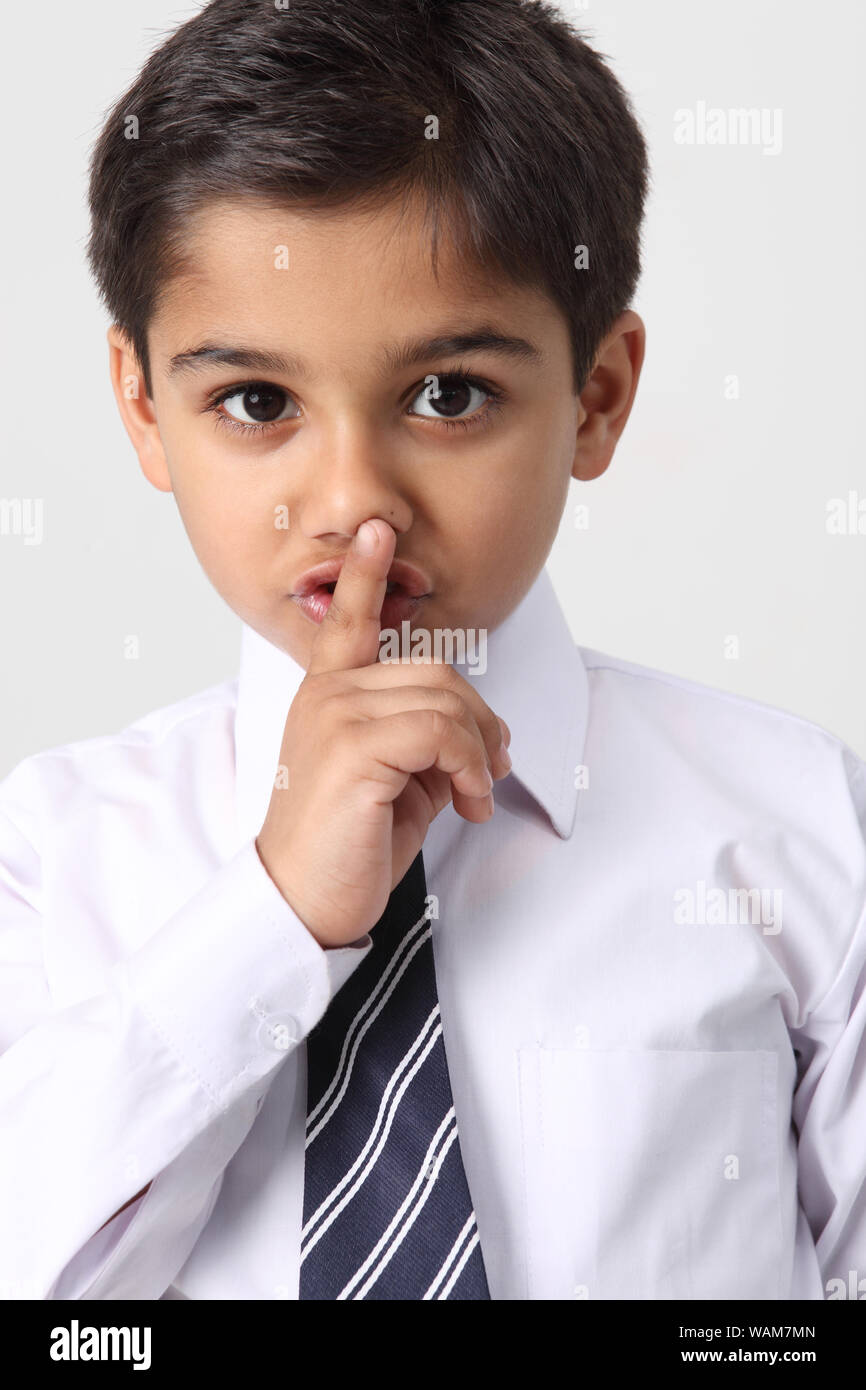 Schoolboy with finger on lips Stock Photo - Alamy