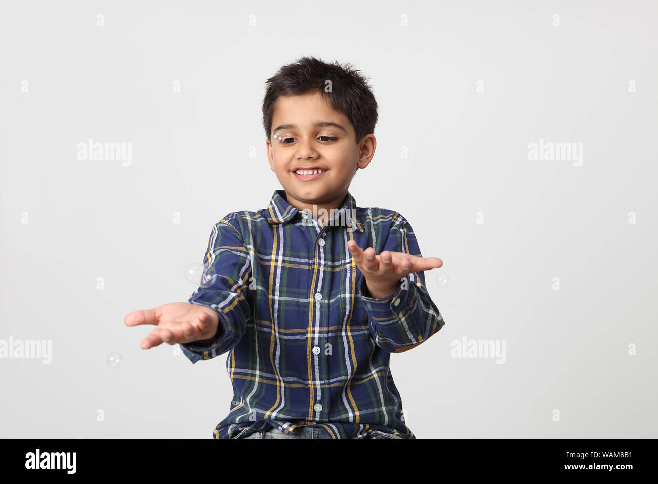 Indian boy catching bubbles Stock Photo - Alamy