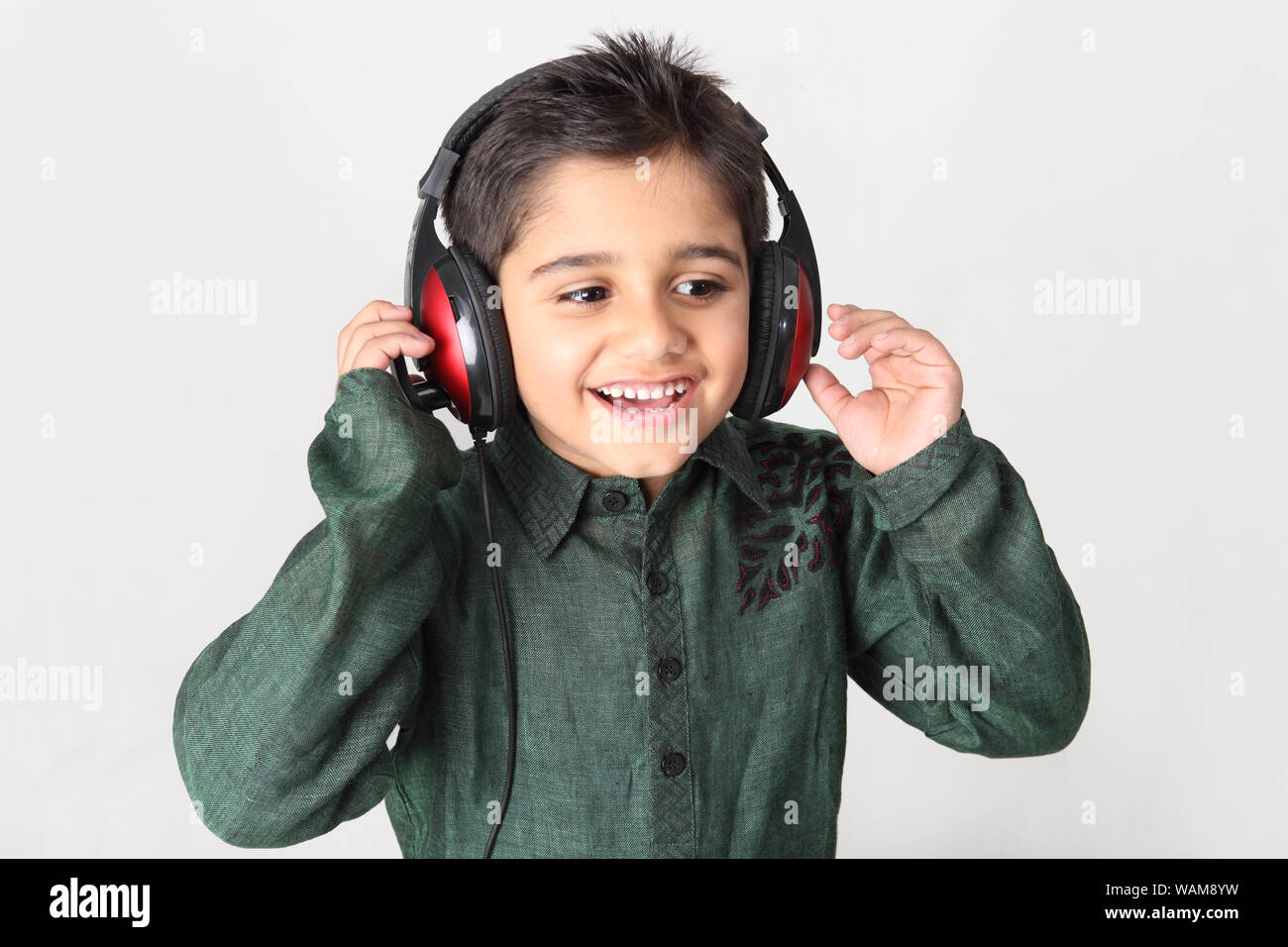 Boy listening to music with headphones and smiling Stock Photo - Alamy