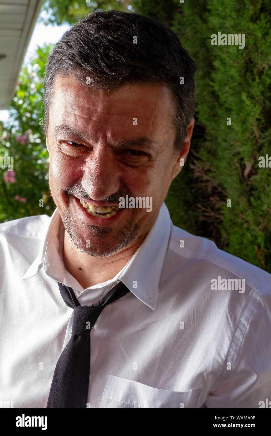 Serious man in outdoor villain style smiling movie with side lighting ...