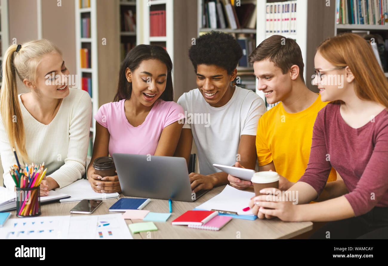 Group of young people working with laptop in library Stock Photo - Alamy