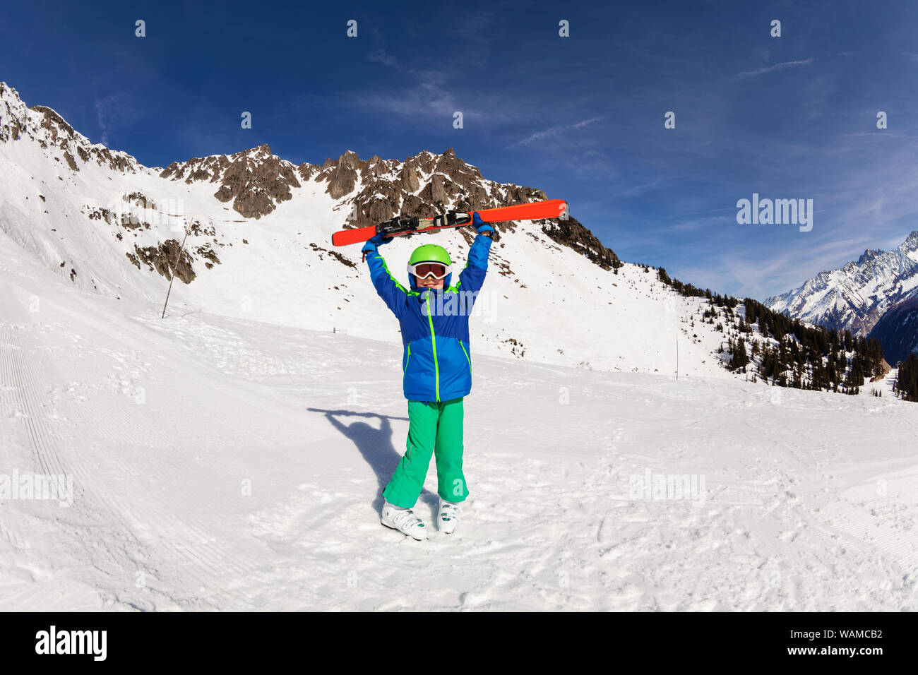 Cool boy hold ski on lifted hands at skiing resort Stock Photo - Alamy