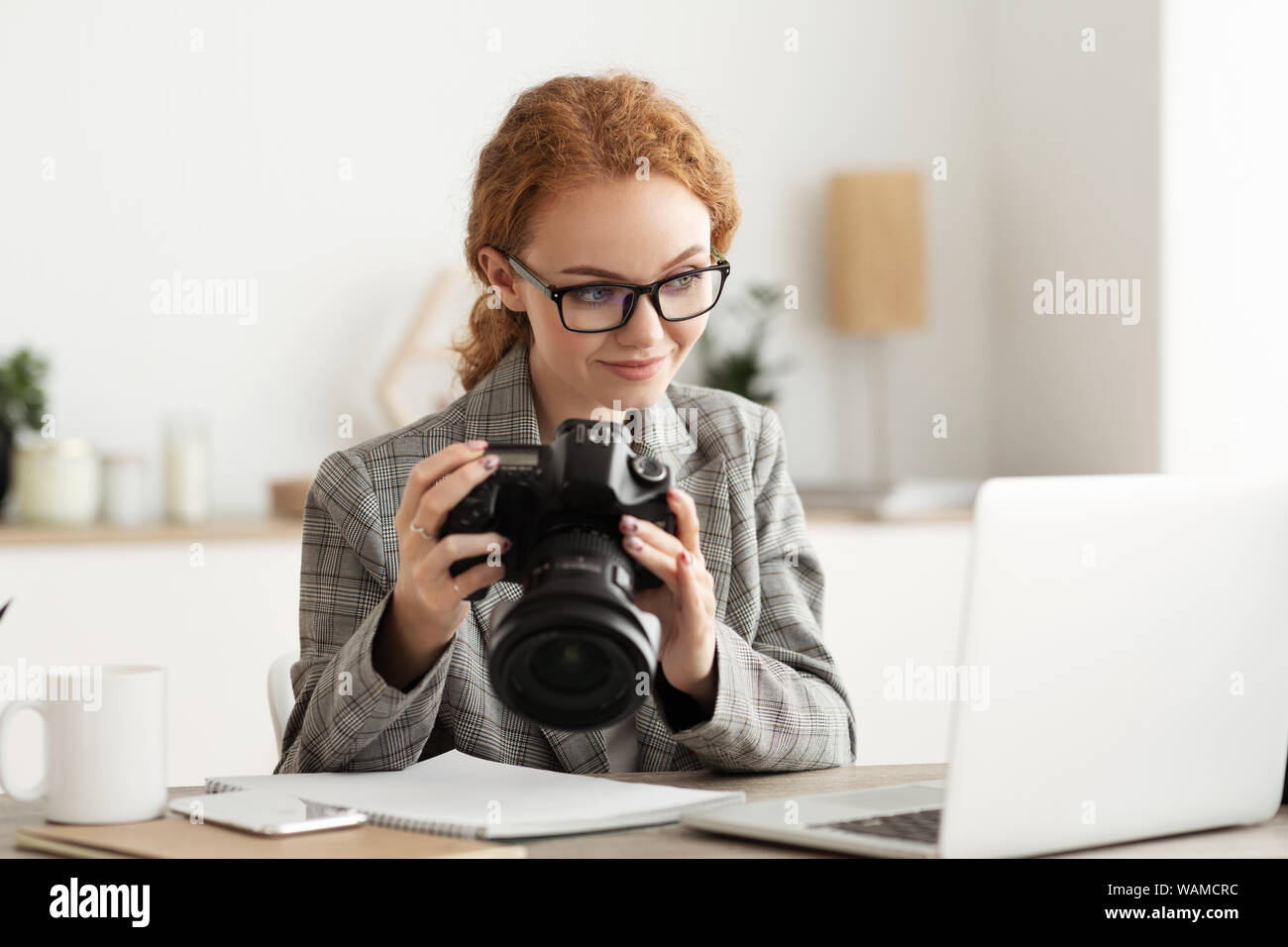 Journalist transfering image data on camera to laptop Stock Photo - Alamy