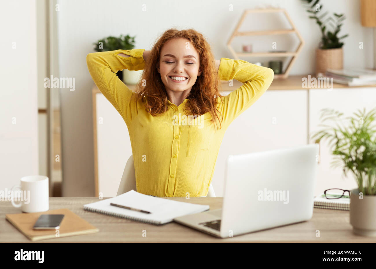 Happy creative designer stretching, working in office Stock Photo - Alamy
