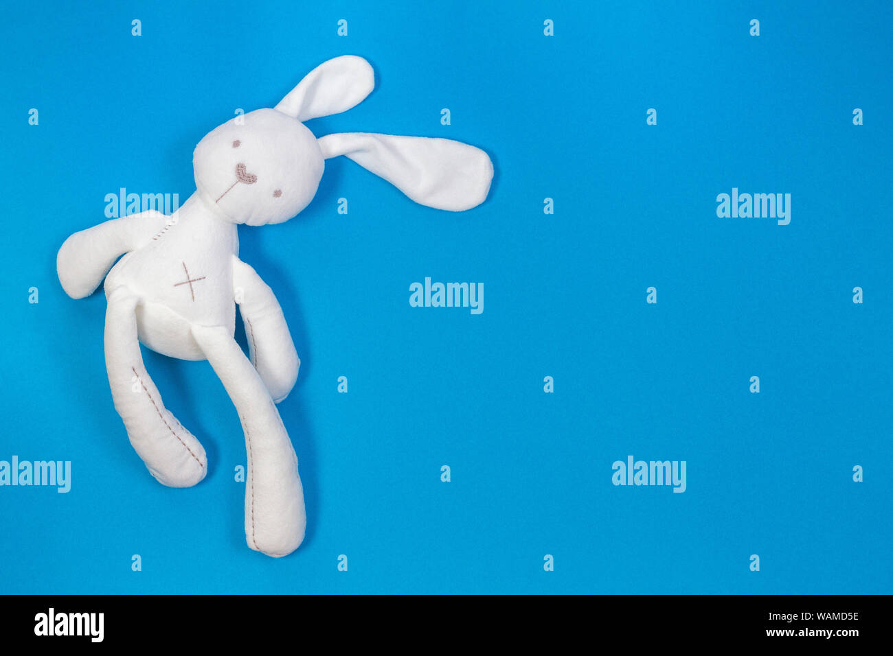 White plush toy rabbit on light sky blue minimal background Stock Photo ...