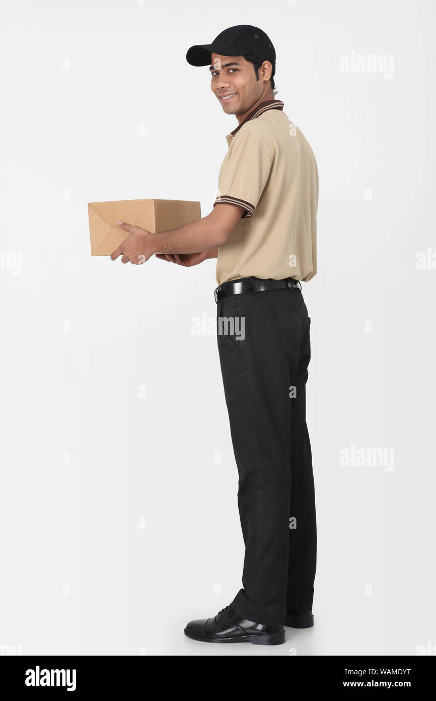 Delivery man holding parcel and smiling Stock Photo - Alamy