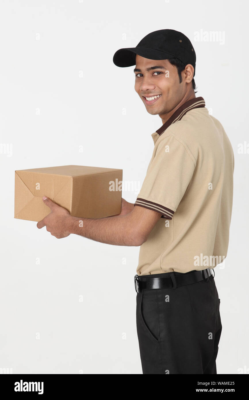 Delivery man holding parcel and smiling Stock Photo - Alamy