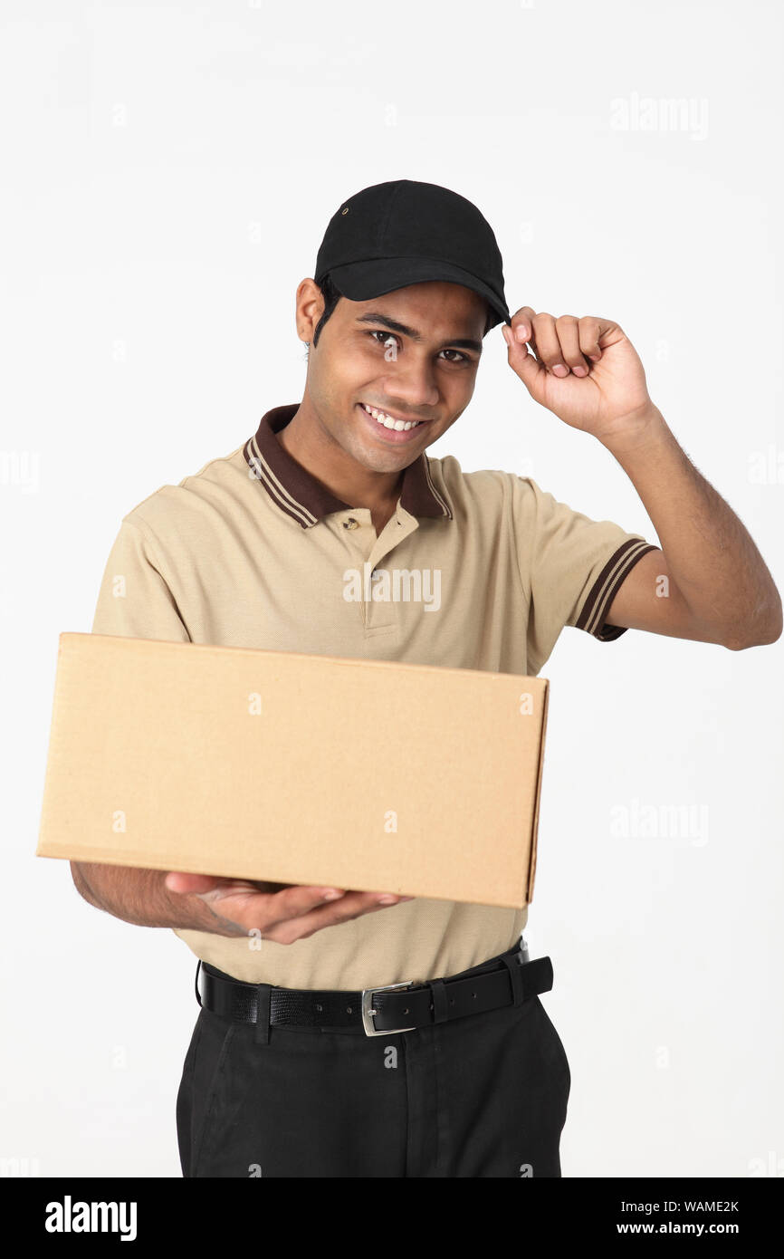 Delivery man holding parcel and smiling Stock Photo - Alamy