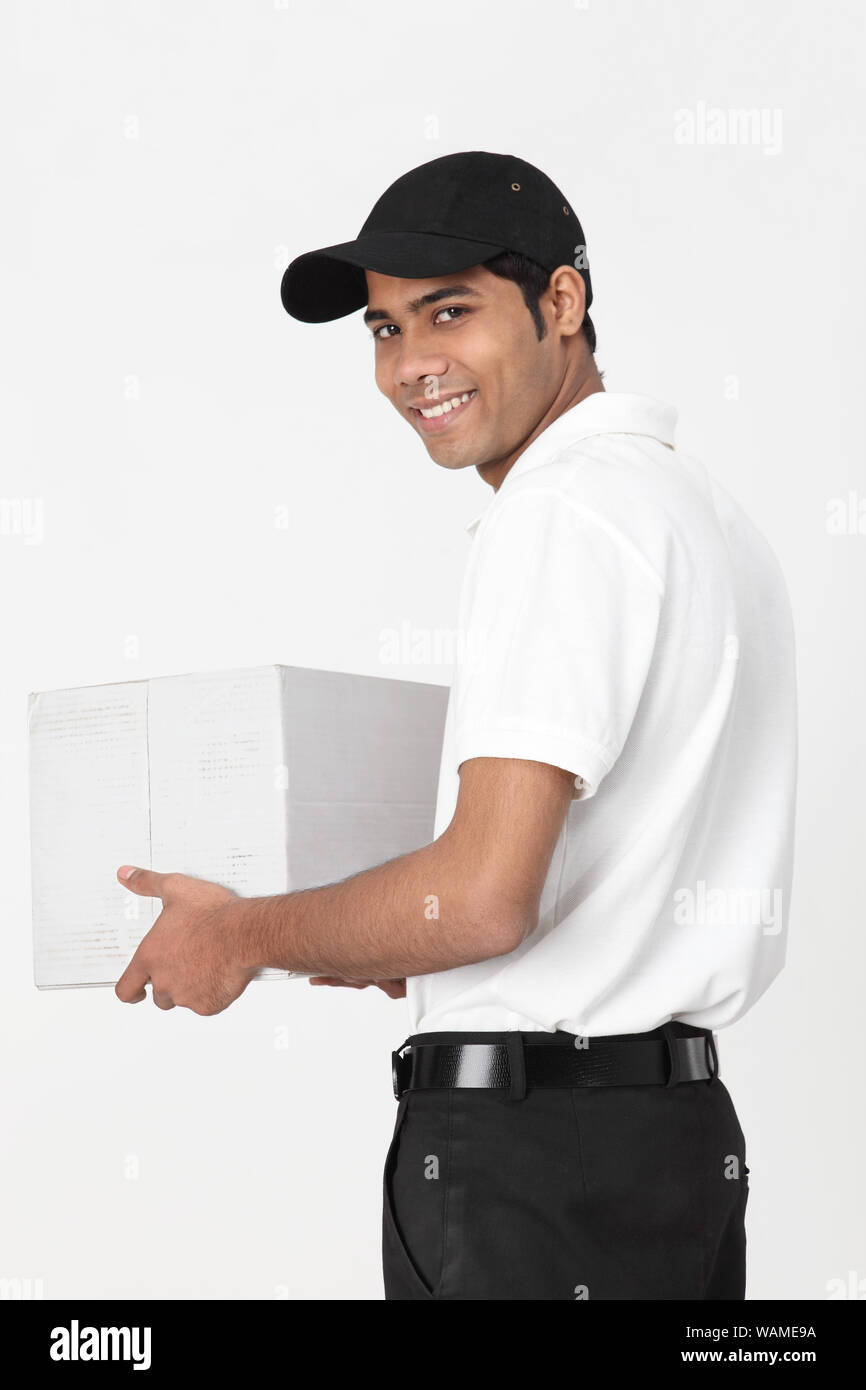 Delivery man holding parcel and smiling Stock Photo - Alamy