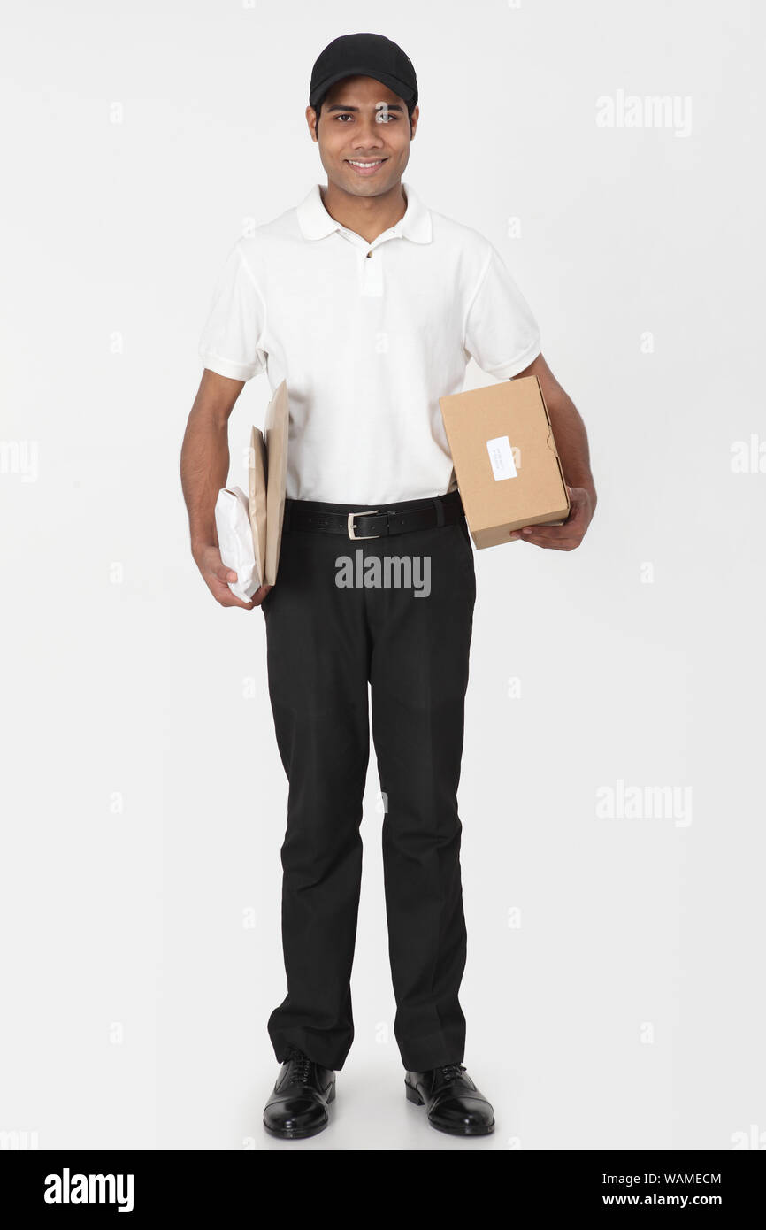 Delivery man holding parcel and smiling Stock Photo - Alamy
