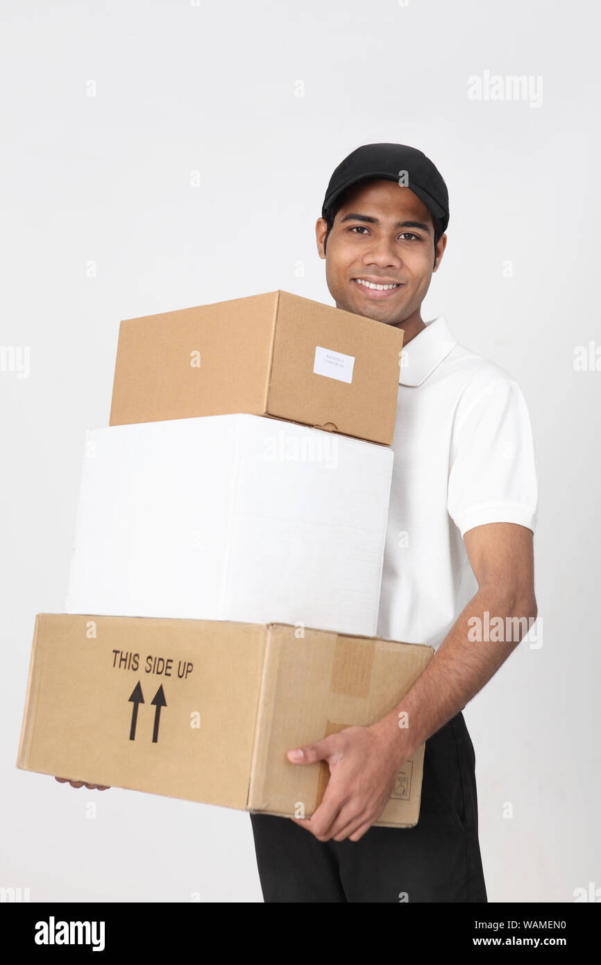 Indian delivery man delivering parcel Stock Photo - Alamy