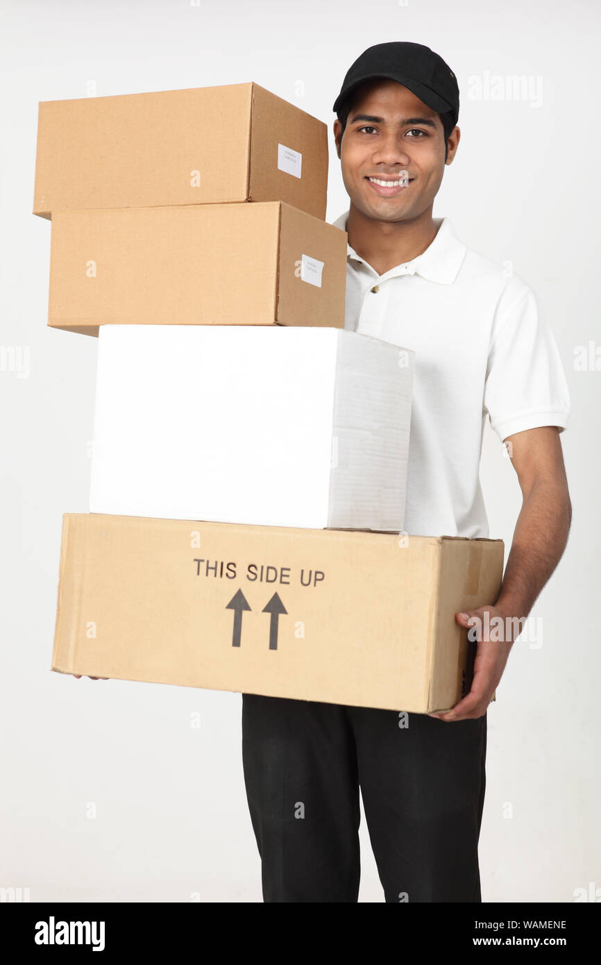 Delivery man carrying stack of parcels and smiling Stock Photo - Alamy