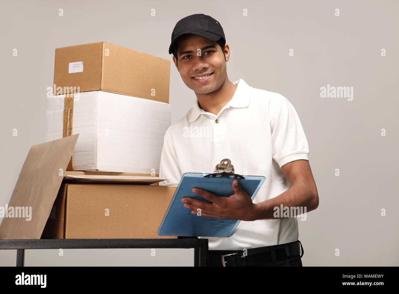Delivery man delivering parcel Stock Photo - Alamy