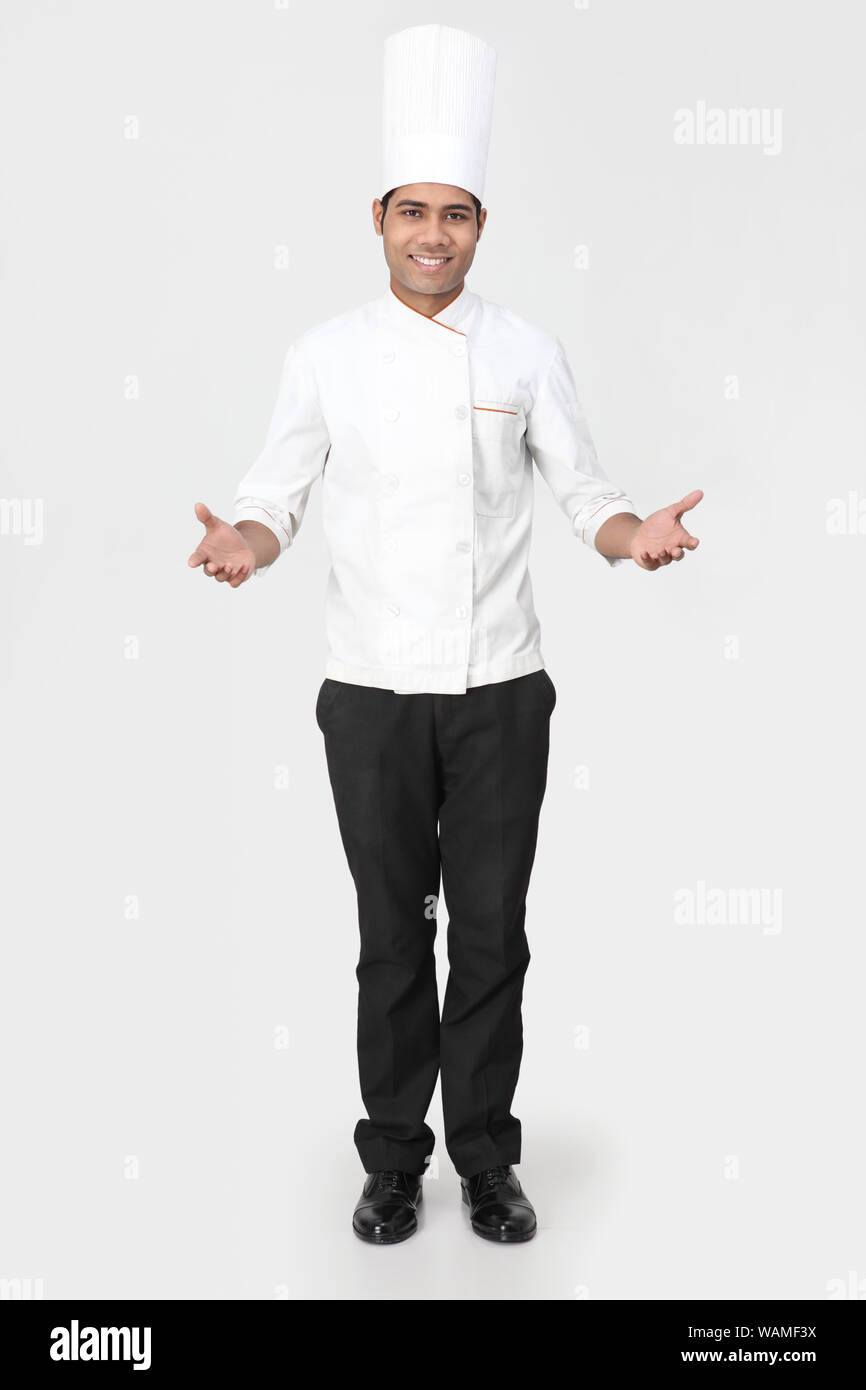 Chef smiling with his arm outstretched Stock Photo - Alamy