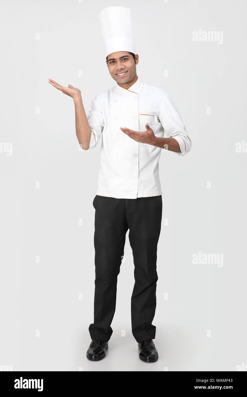 Chef smiling with his arm outstretched Stock Photo - Alamy