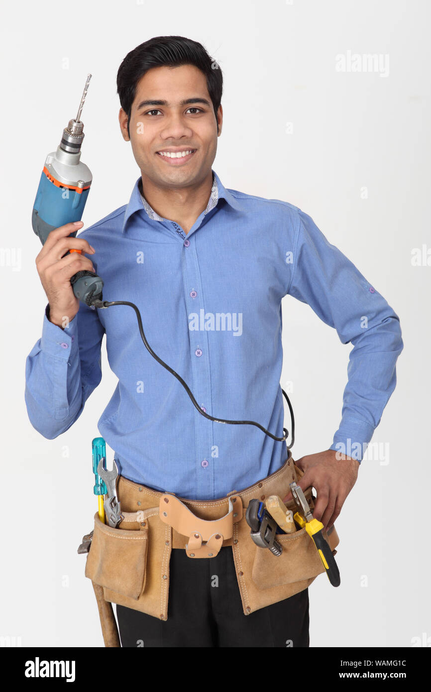 Electrician standing with drill and smiling Stock Photo - Alamy