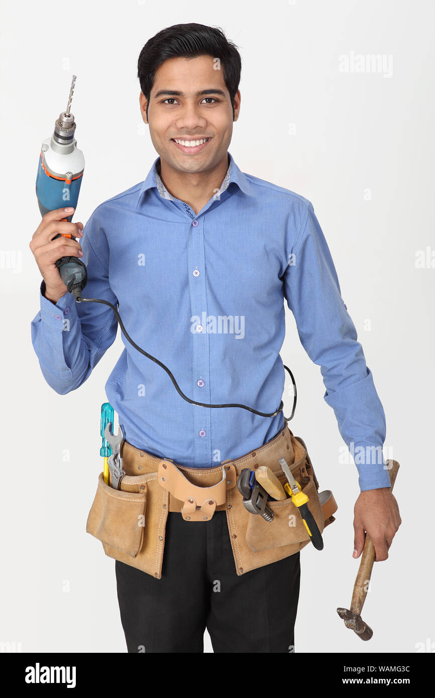 Electrician standing with drill and smiling Stock Photo - Alamy