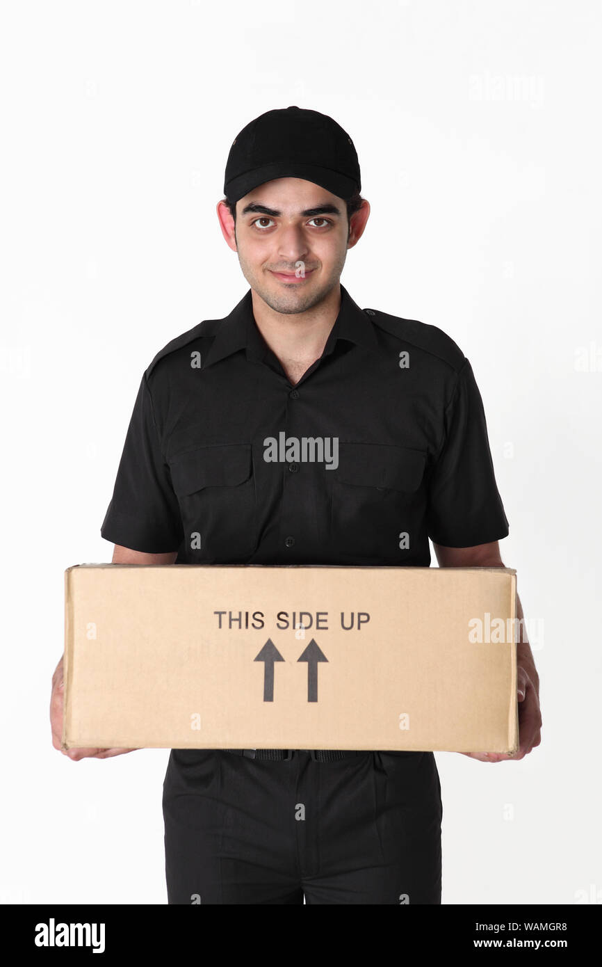 Delivery man standing with parcel Stock Photo - Alamy