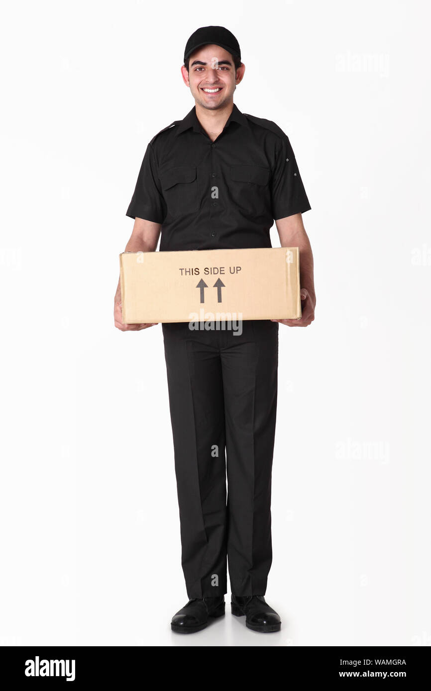 Delivery man standing with parcel Stock Photo - Alamy