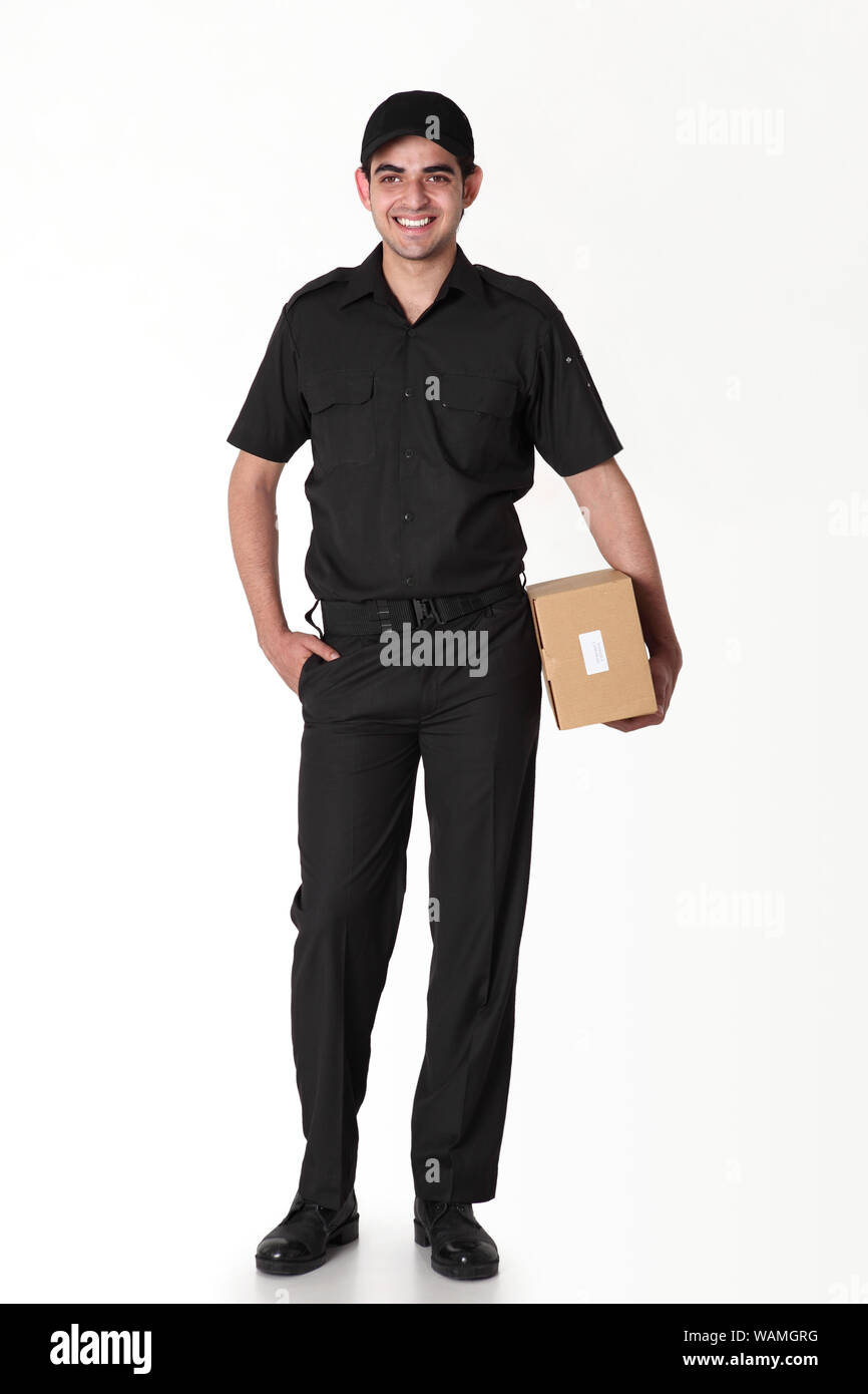 Delivery man standing with parcel Stock Photo - Alamy