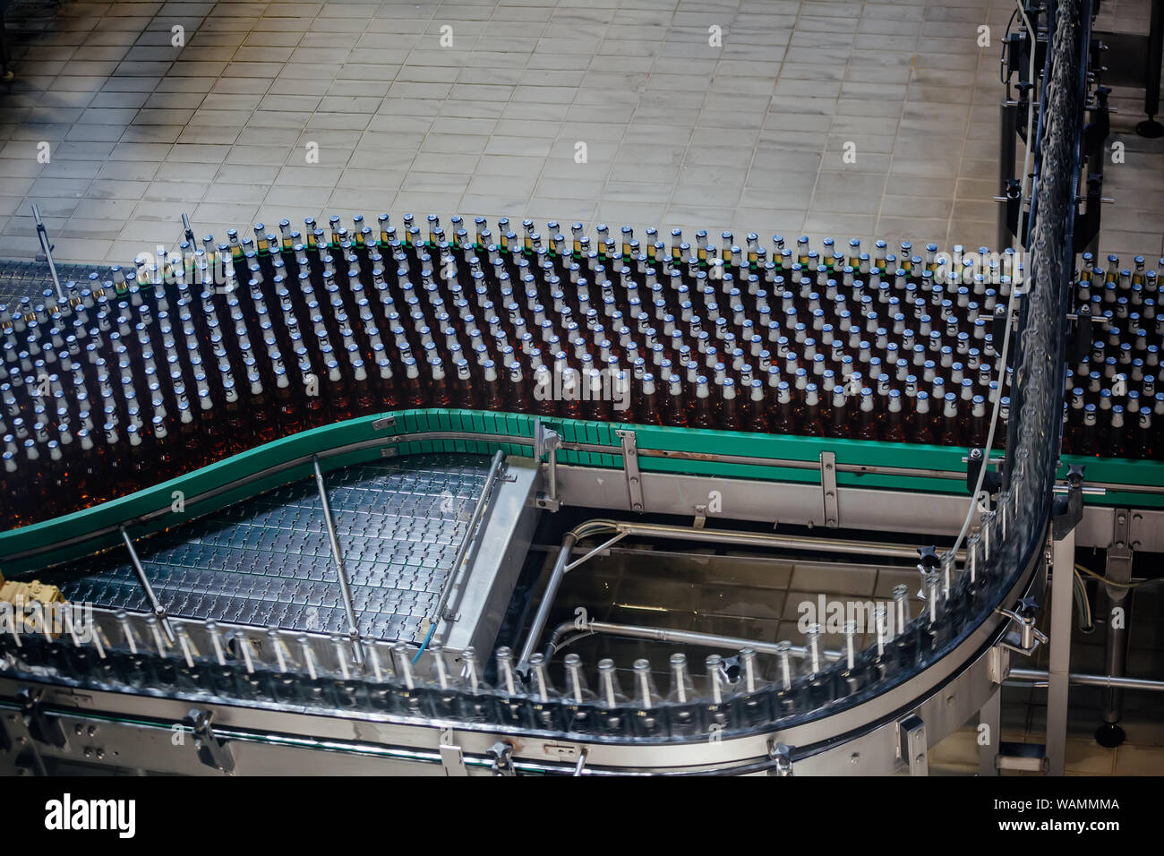 Modern automated beer bottling production line. Beer bottles moving on ...