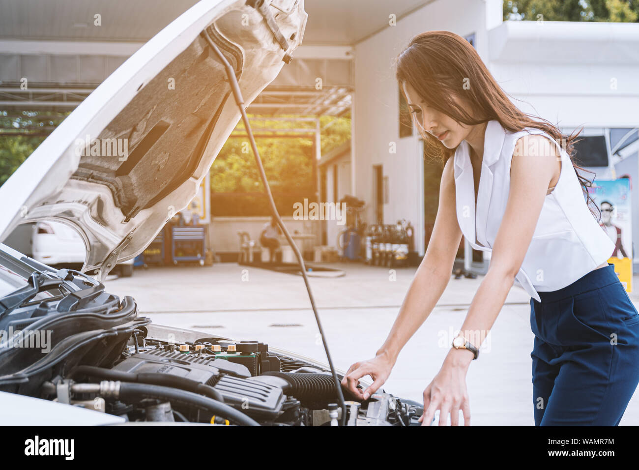 Asian woman the car is broken. Open the bonnet, check engine Stock ...