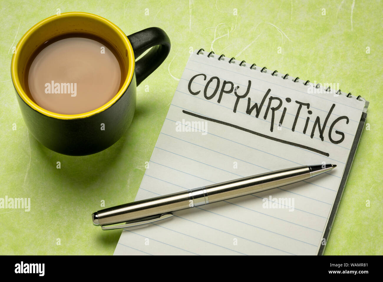 copywriting word - handwriting in a spiral notebooks with a cup of ...