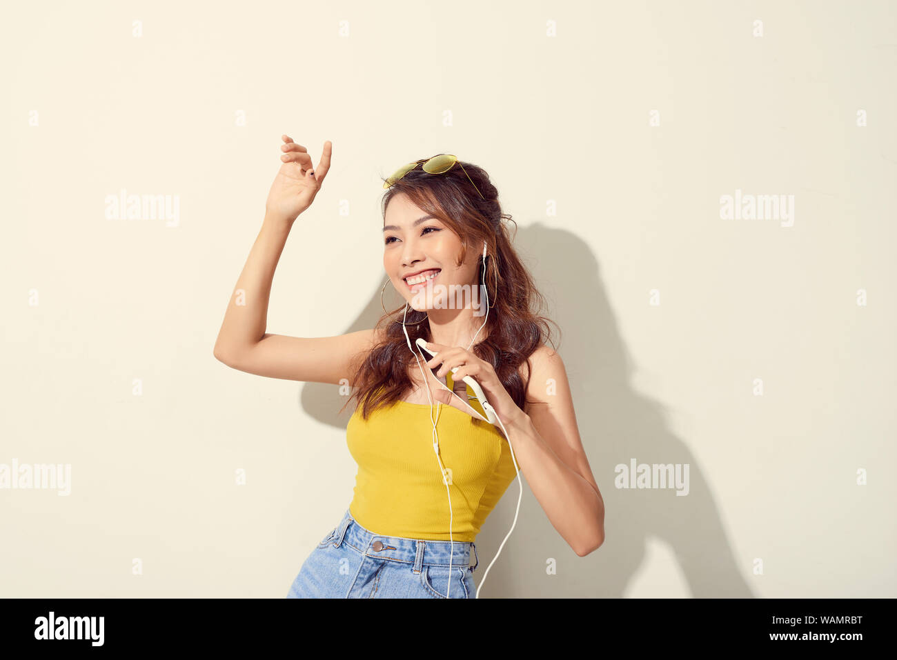 Asian Woman dancing with mobile phone on the white background Stock ...