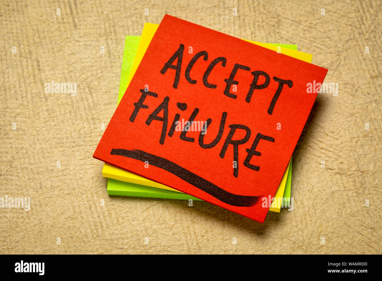 accept failure - handwriting on a reminder note against textured paper ...