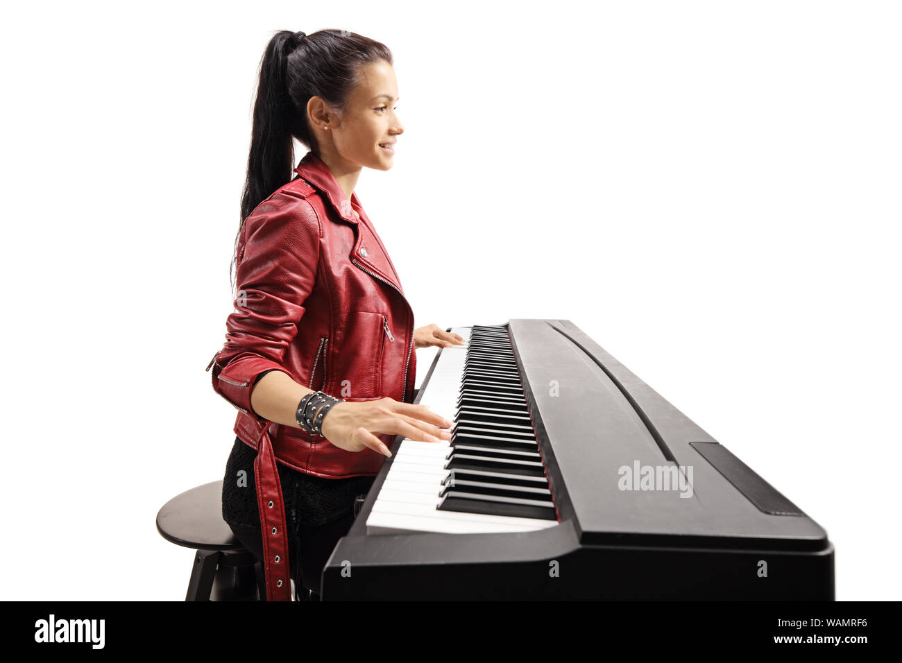 Profile shot of a trendy young female playing keyboard isolated on ...