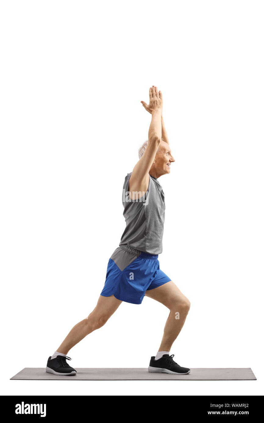 Full length profile shot of a senior man practicing yoga pose on an ...