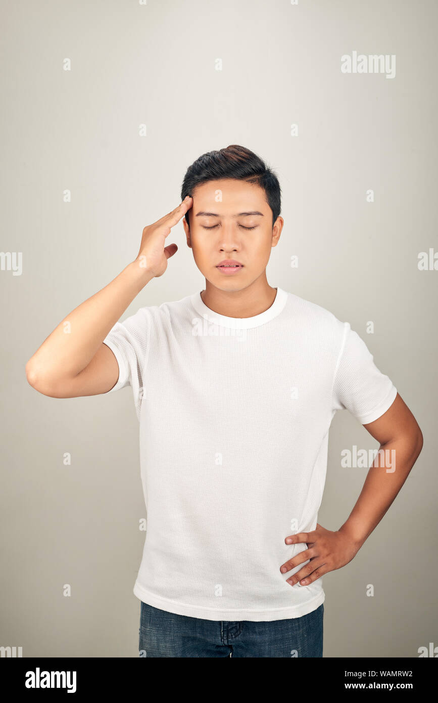 Good-looking asian man showing how much his head hurts, experiencing ...