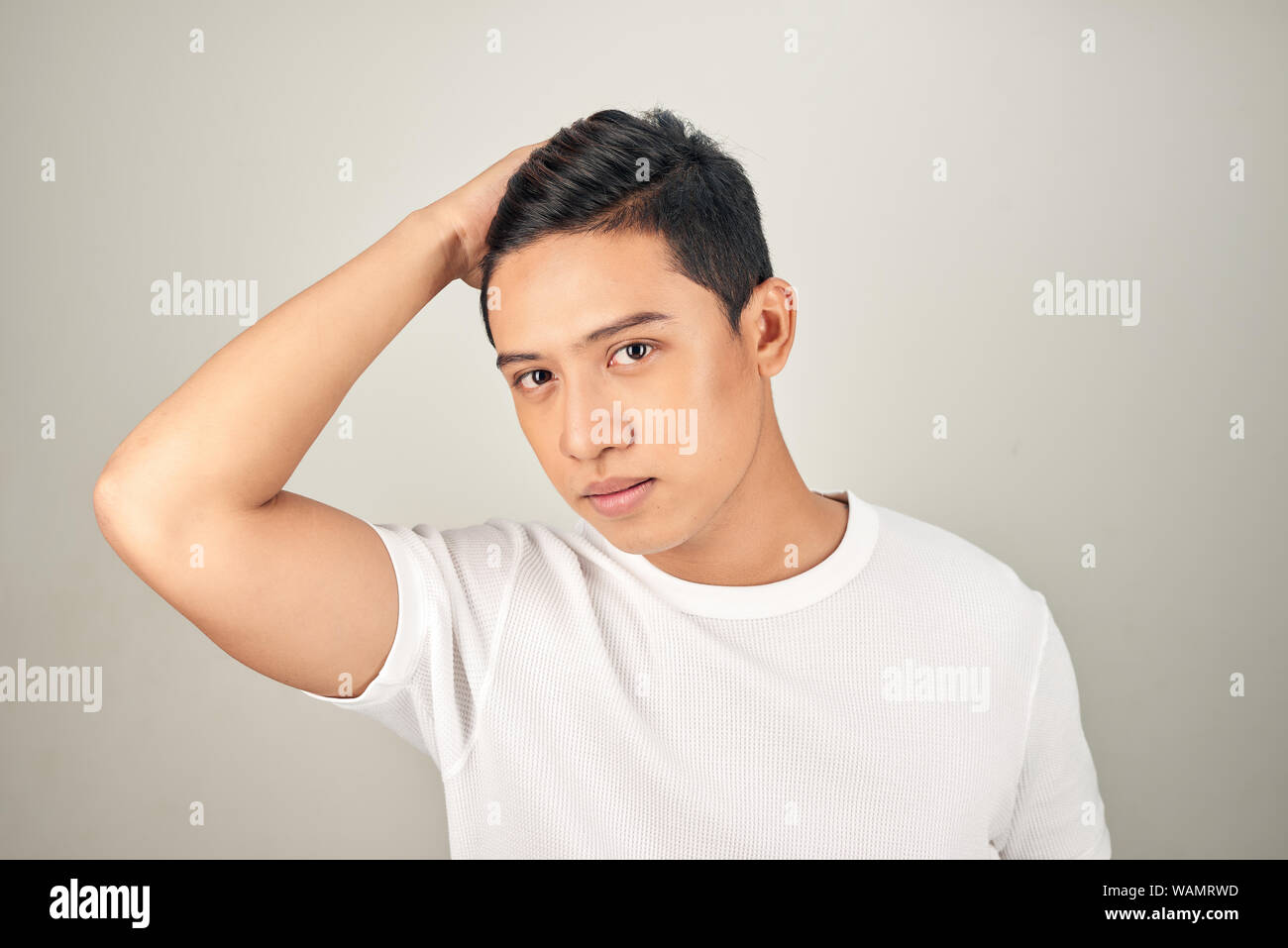 Fashion portrait of a handsome man. Man runs a hand through his hair ...
