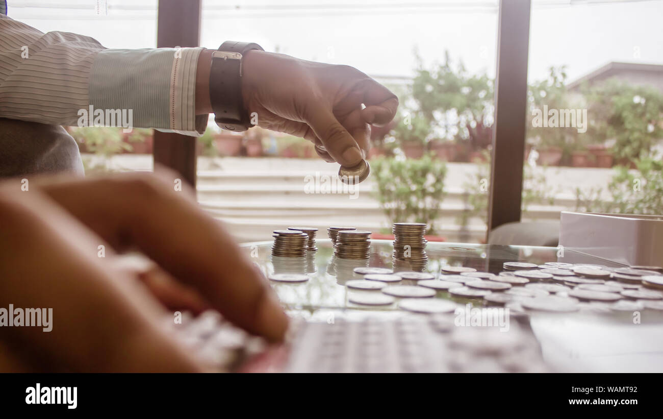 Image Of Businessman counting coins Using Calculator at Desk In Office ...