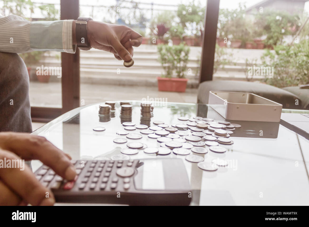 Image Of Businessman counting coins Using Calculator at Desk In Office ...