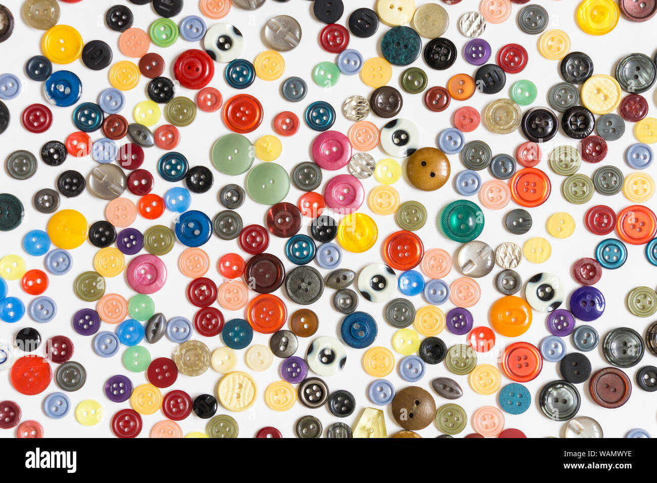 background - multicolored plain buttons chaotically arranged on a white ...
