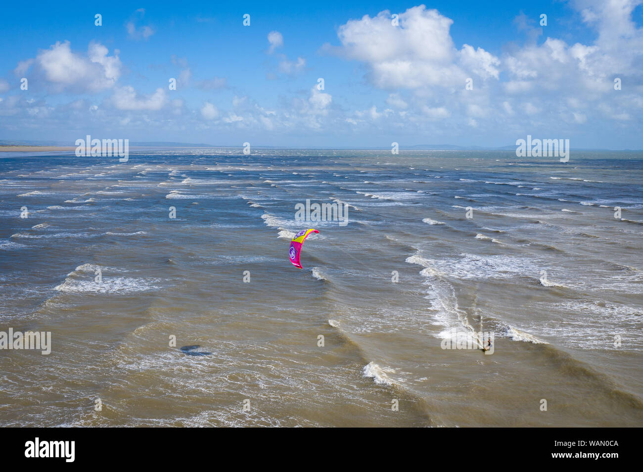 Aerial view of person kite surfing on the water of pendine sands beach ...