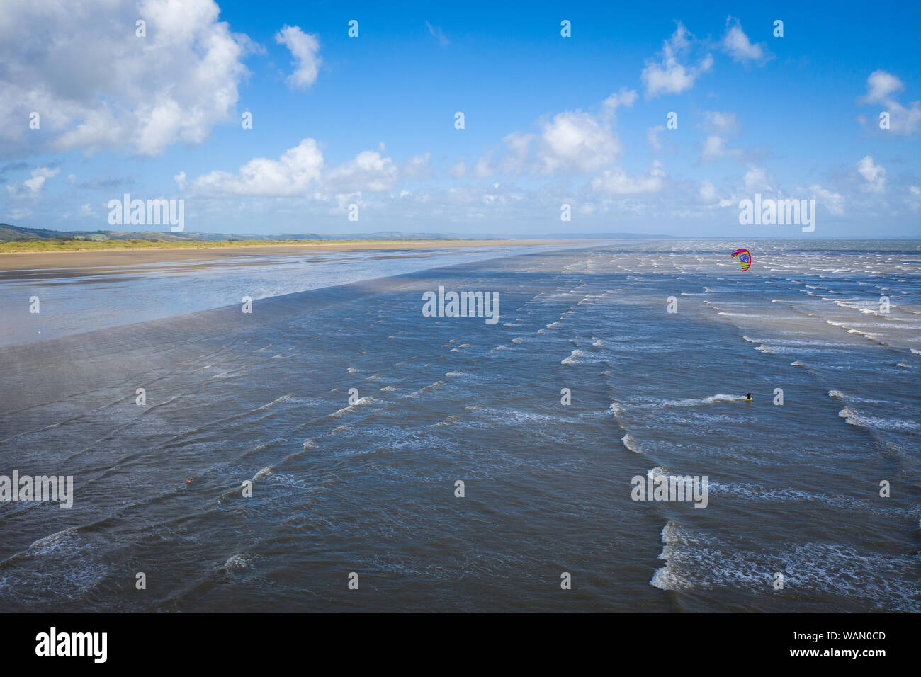 Aerial view of person kite surfing on the water of pendine sands beach ...